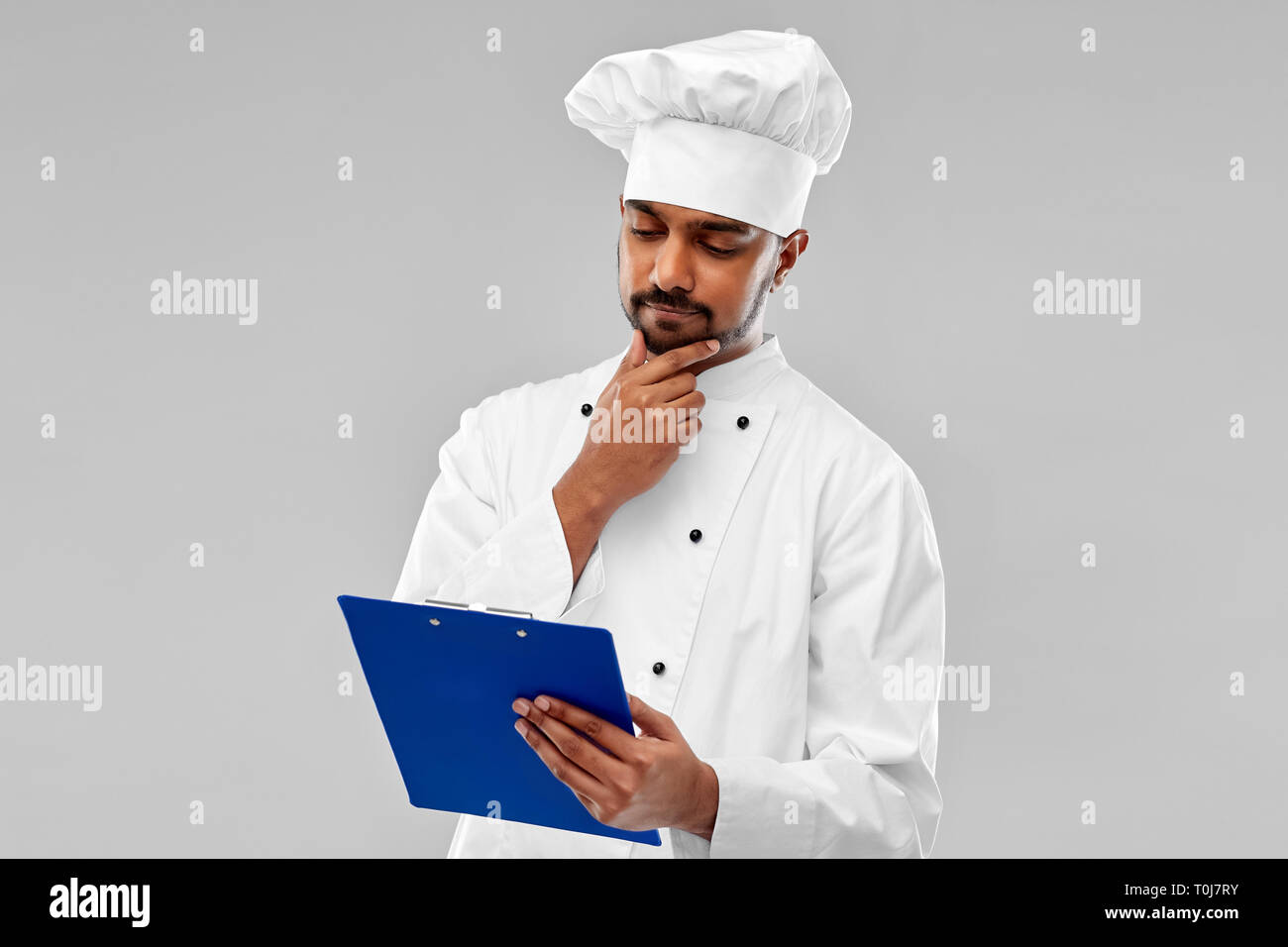 male indian chef reading menu on clipboard Stock Photo - Alamy