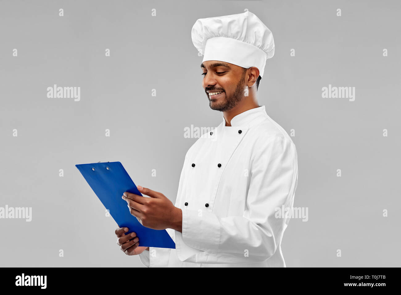 happy male indian chef in toque with clipboard Stock Photo - Alamy