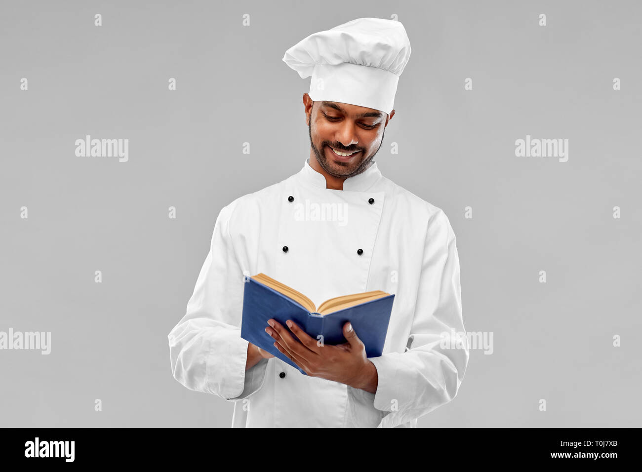 happy male indian chef reading cookbook Stock Photo - Alamy