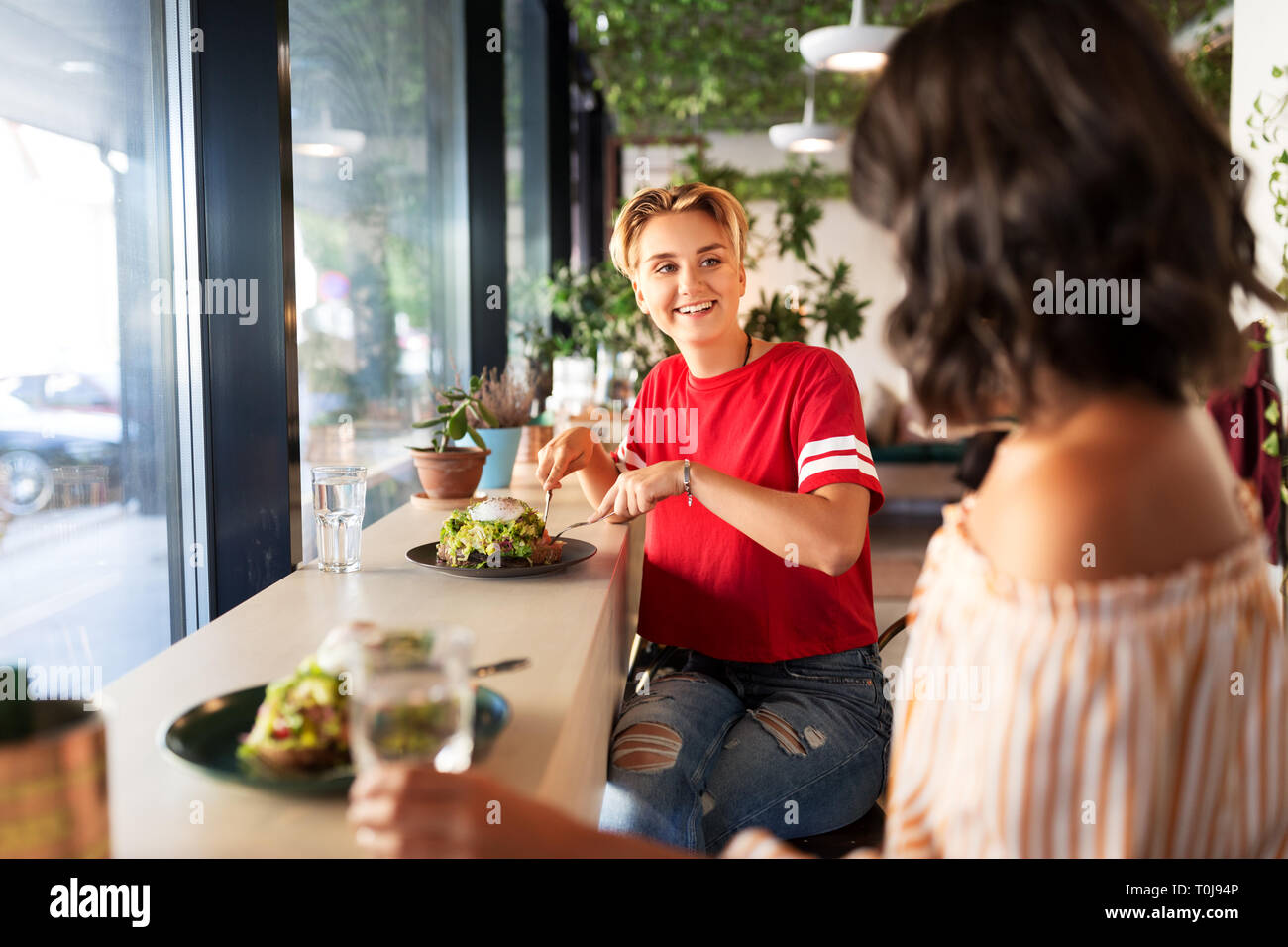 female friends eating at restaurant Stock Photo - Alamy