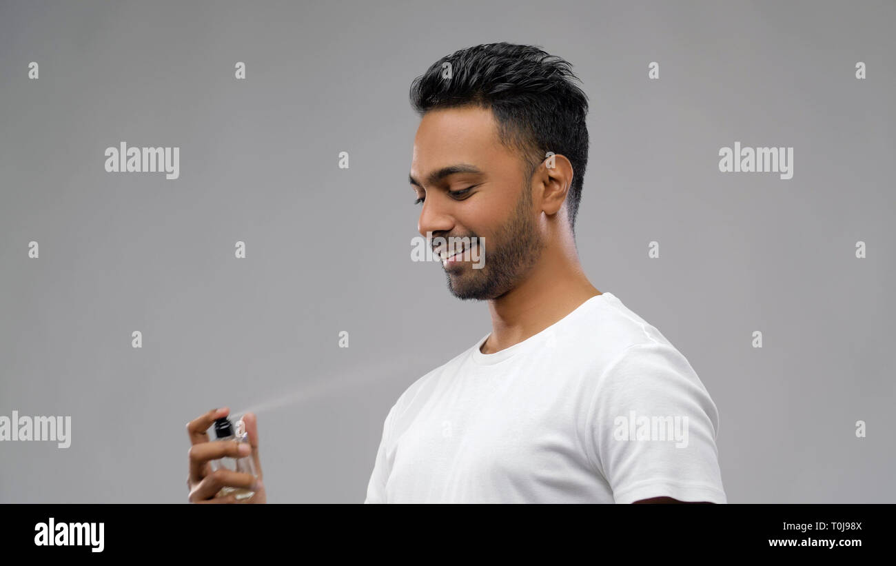 happy indian man with perfume over grey background Stock Photo - Alamy