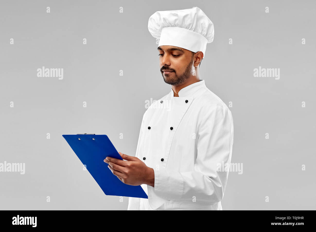 male indian chef reading menu on clipboard Stock Photo - Alamy