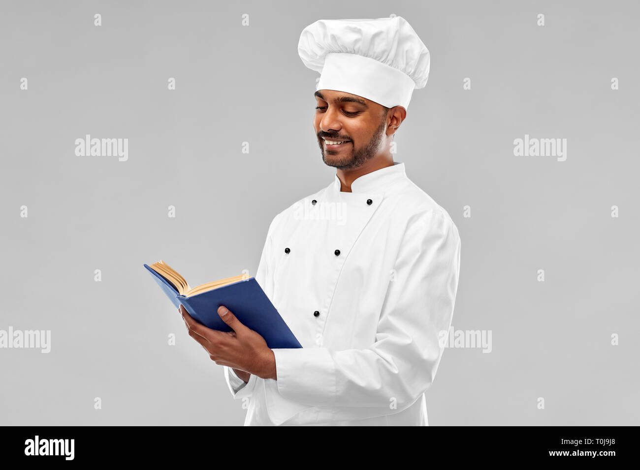 happy male indian chef reading cookbook Stock Photo - Alamy