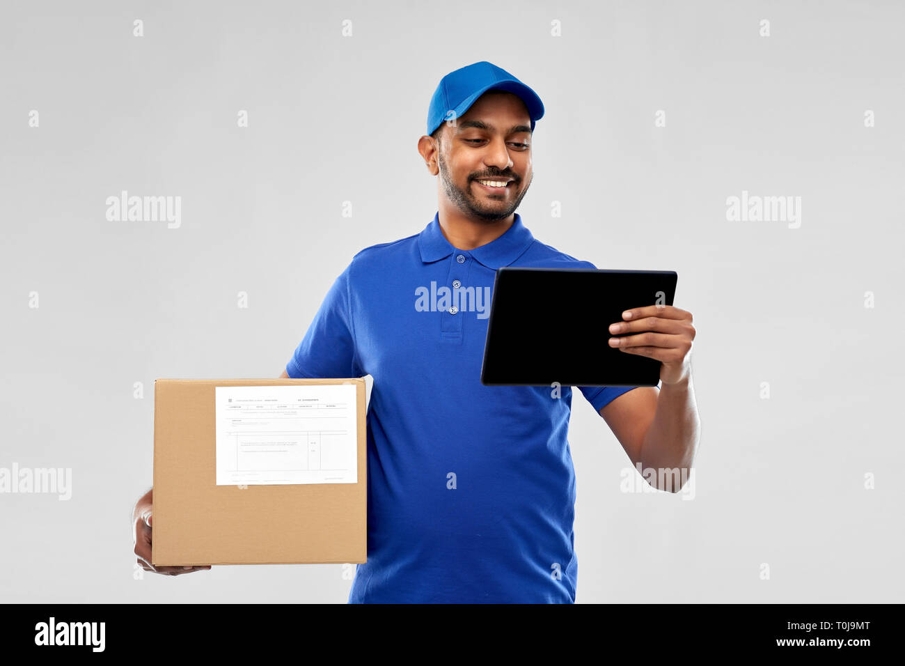 indian delivery man with tablet pc and parcel box Stock Photo - Alamy