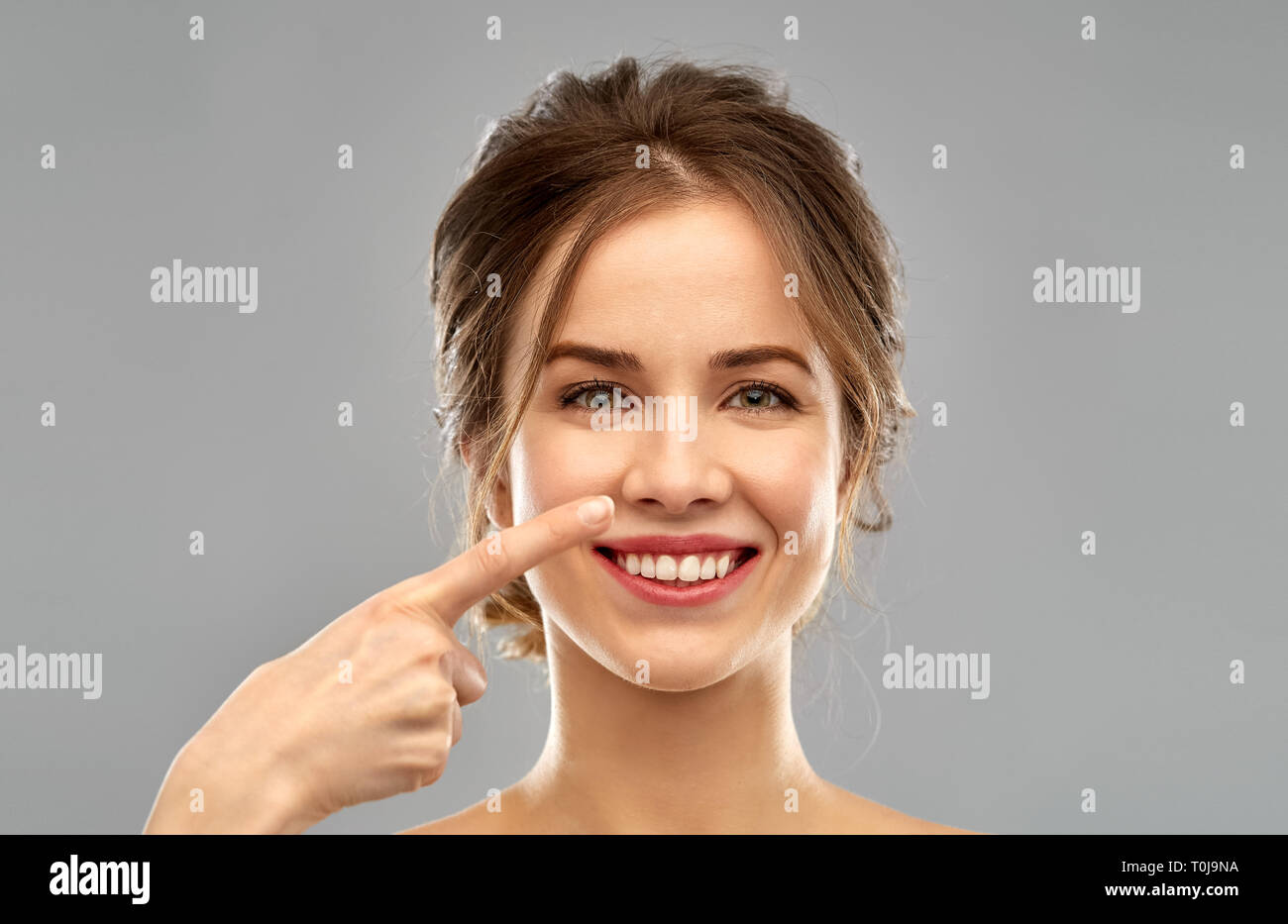 beautiful young woman pointing to her nose Stock Photo - Alamy