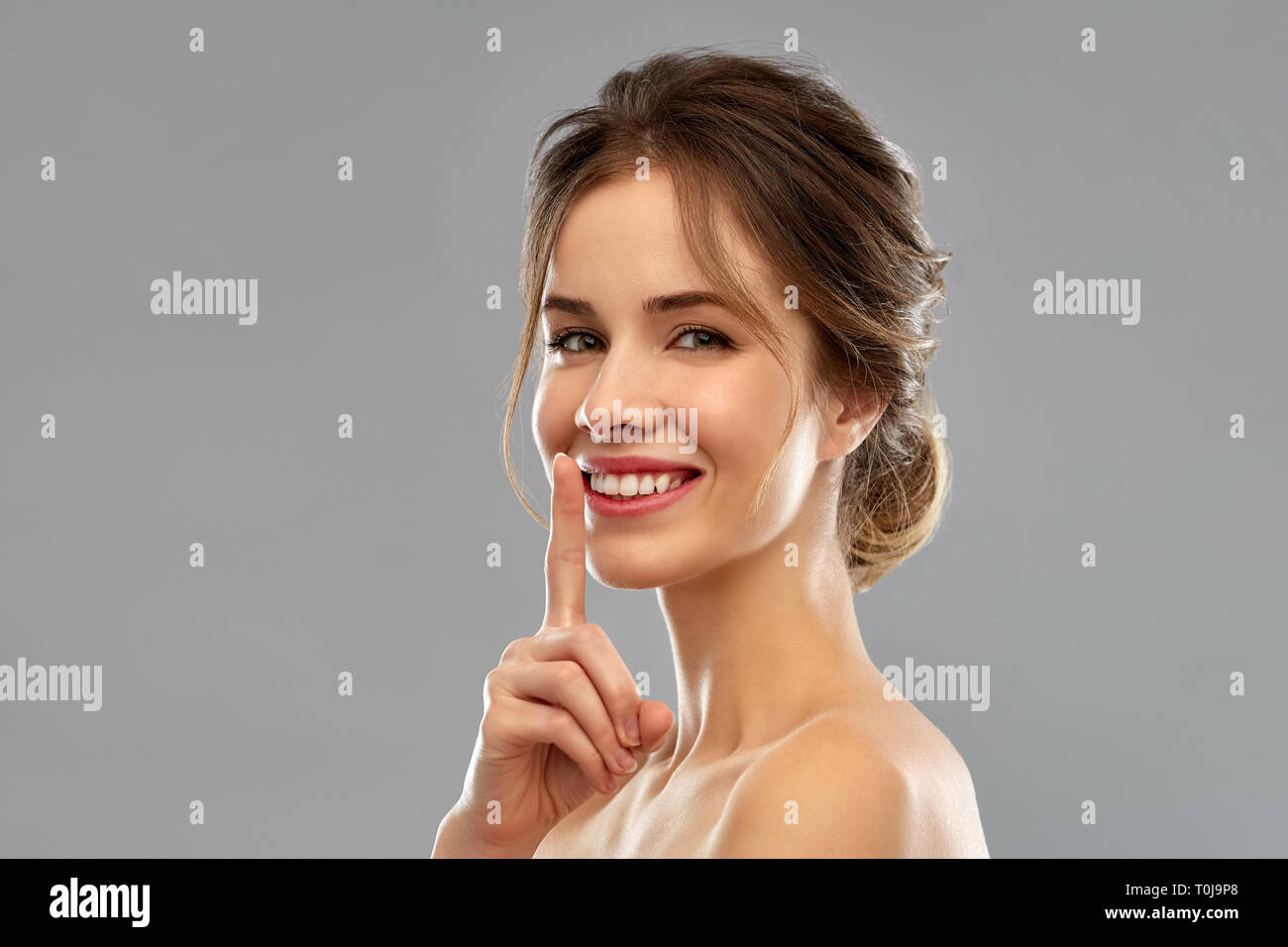 beautiful smiling woman making hush gesture Stock Photo - Alamy