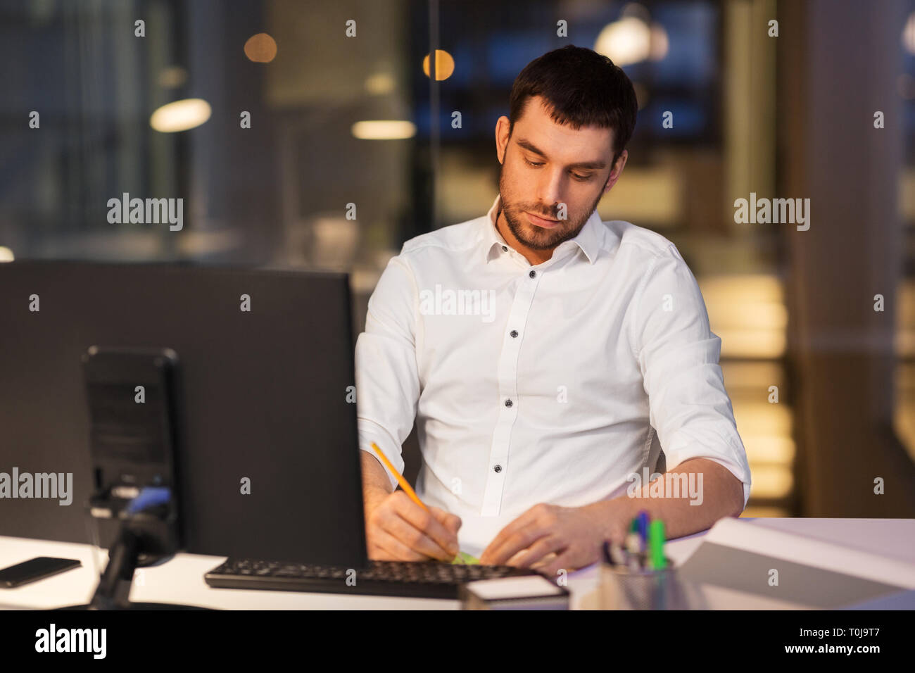 businessman with computer working at night office Stock Photo - Alamy