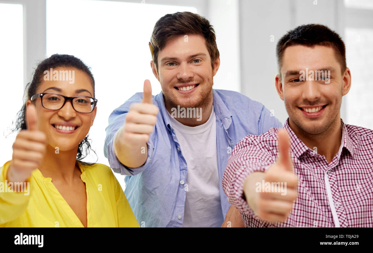 happy creative team showing thumbs up at office Stock Photo - Alamy