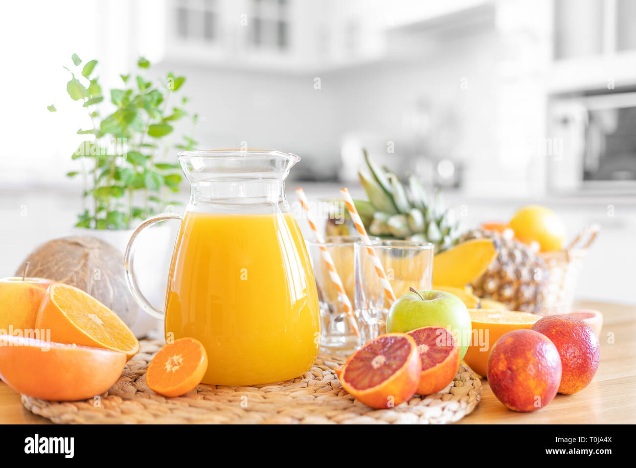 Multifruit juice and fresh fruit on table on kitchen background closeup ...