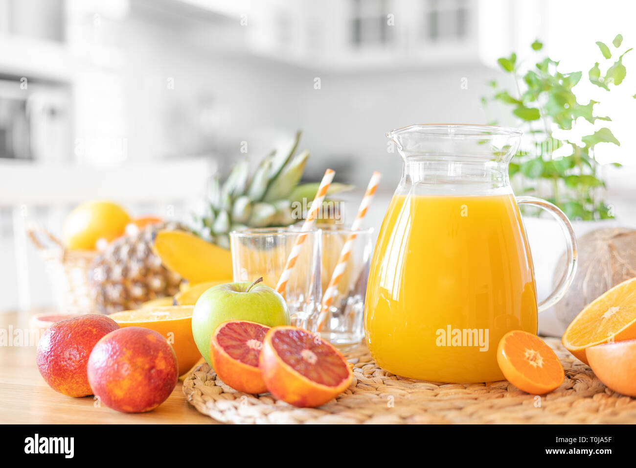 Multifruit juice and fresh fruit on table on kitchen background closeup ...