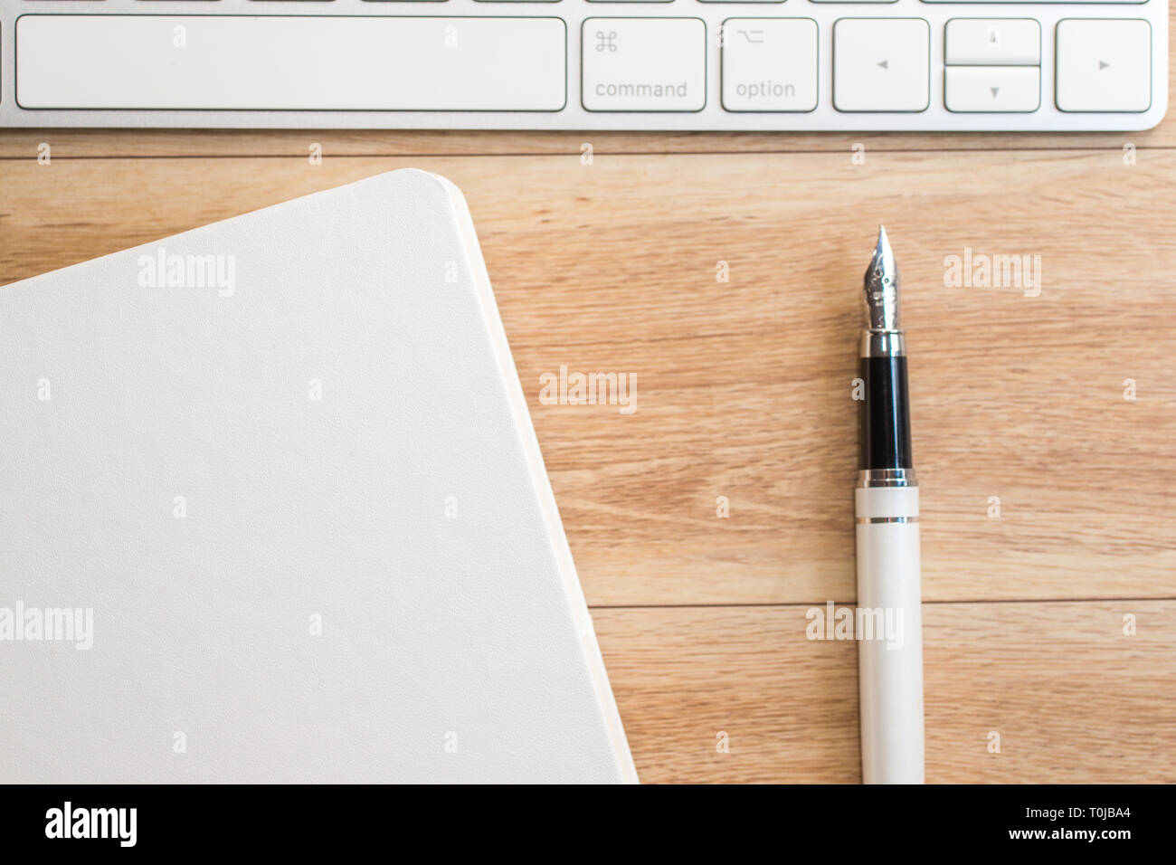 Office table with notepad, keyboard and fountain pen. View from above ...