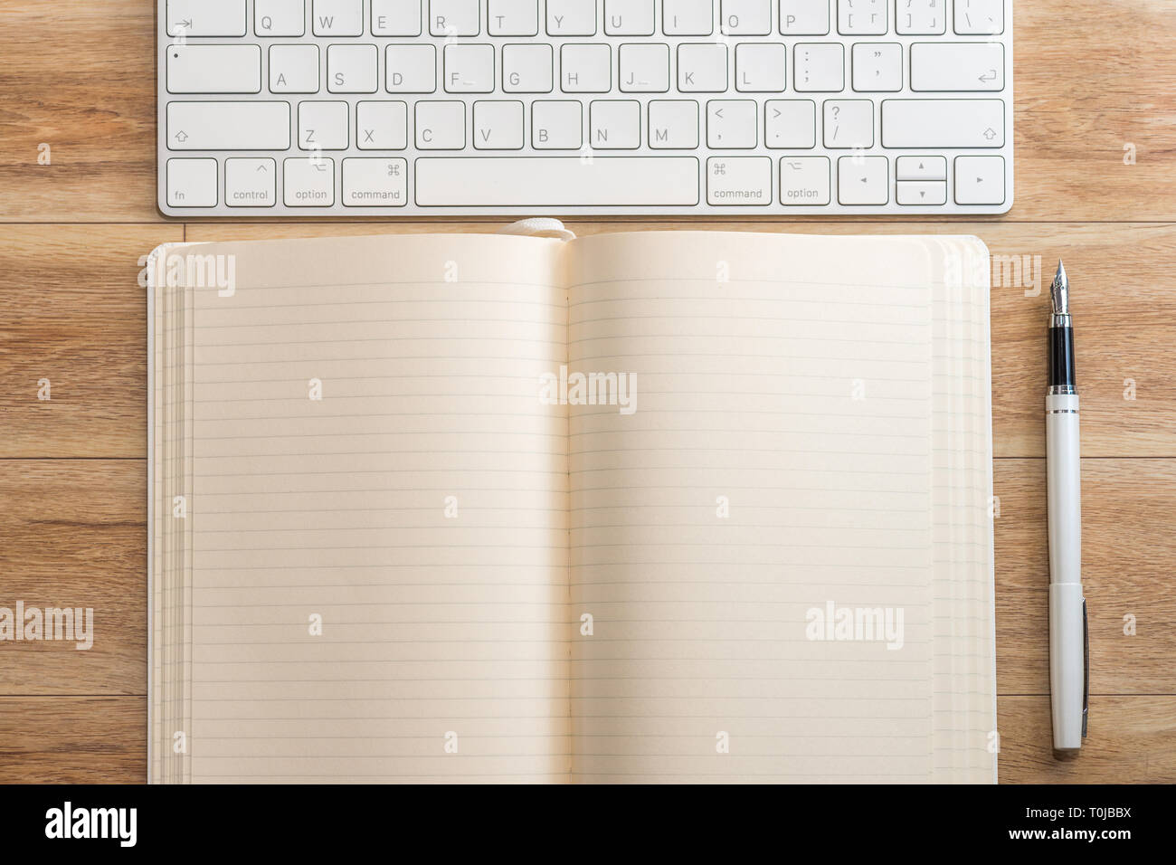 Office table with notepad, keyboard and fountain pen. View from above ...