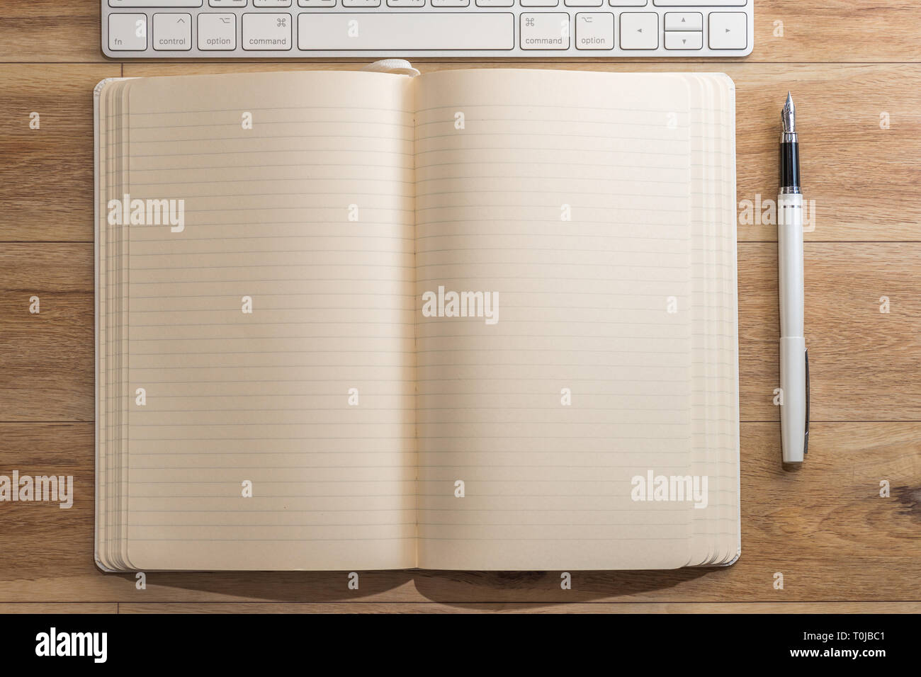 Office table with notepad, keyboard and fountain pen. View from above ...