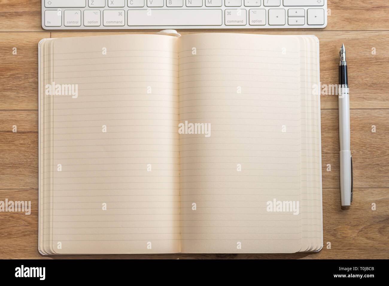 Office table with notepad, keyboard and fountain pen. View from above ...