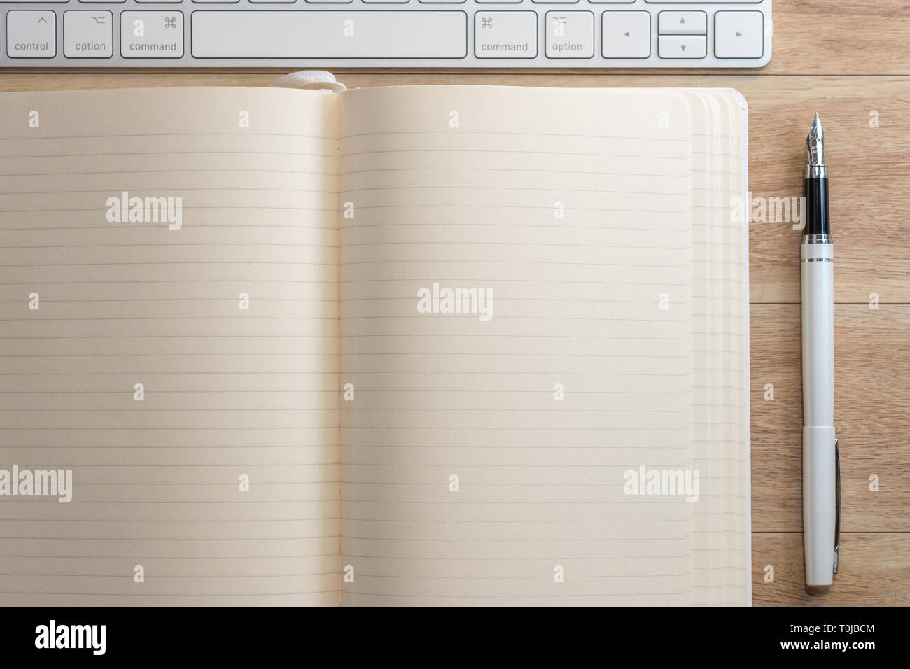 Office table with notepad, keyboard and fountain pen. View from above ...