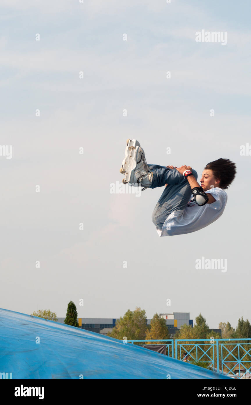 Skater performing jumping in mid air mid-air on bright sunny day Stock ...