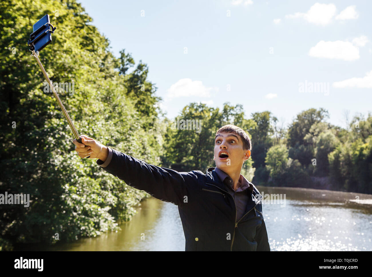 Happy man holding selfie stick hi-res stock photography and images - Alamy