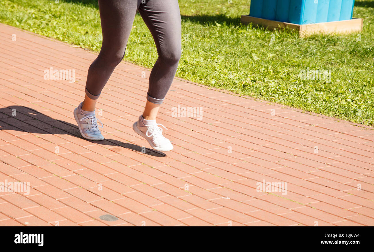 legs of girl running in a sports competition on sunny summer morning ...