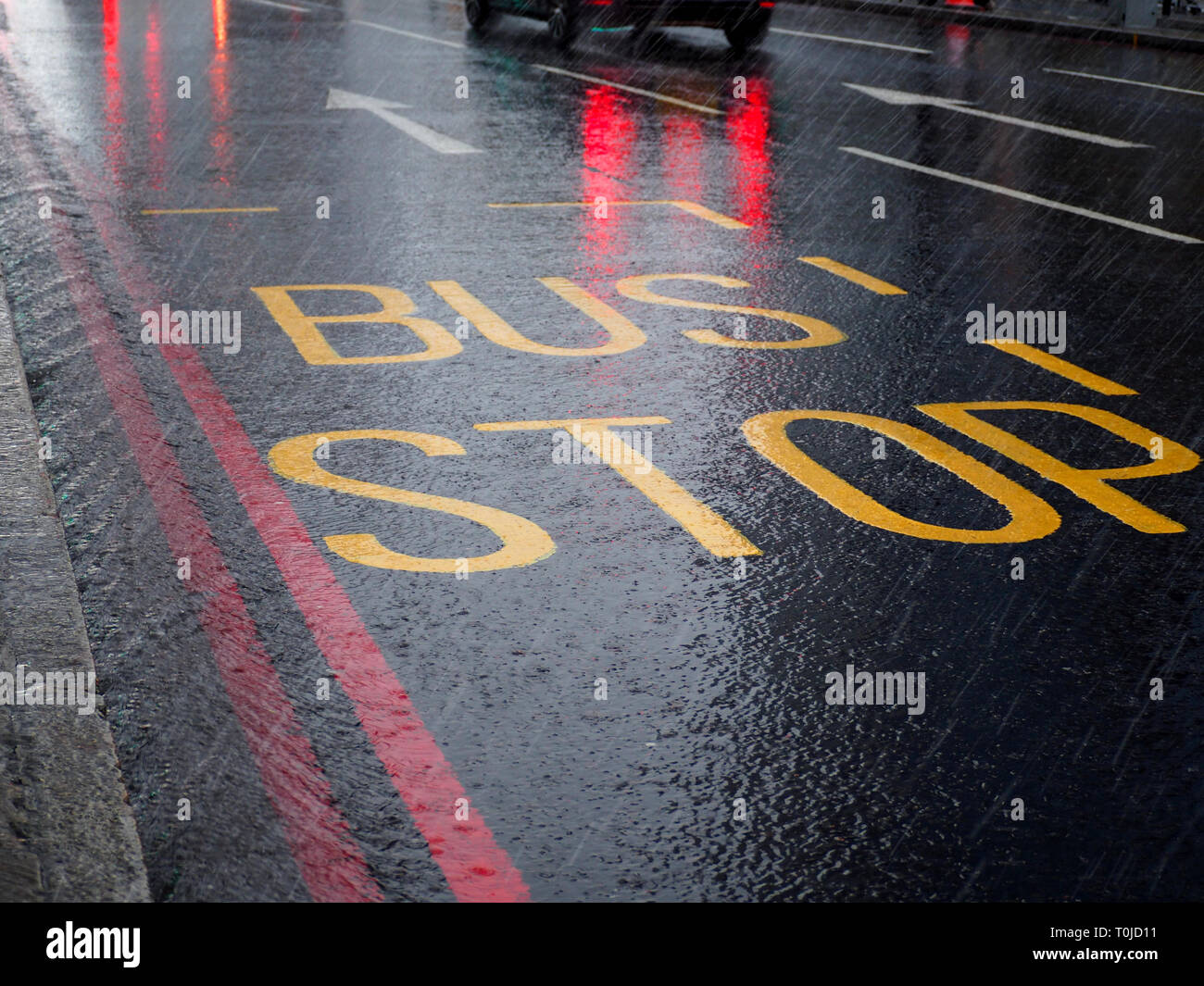 Bus Stop road marking in heavy rain, London, England, UK Stock Photo ...