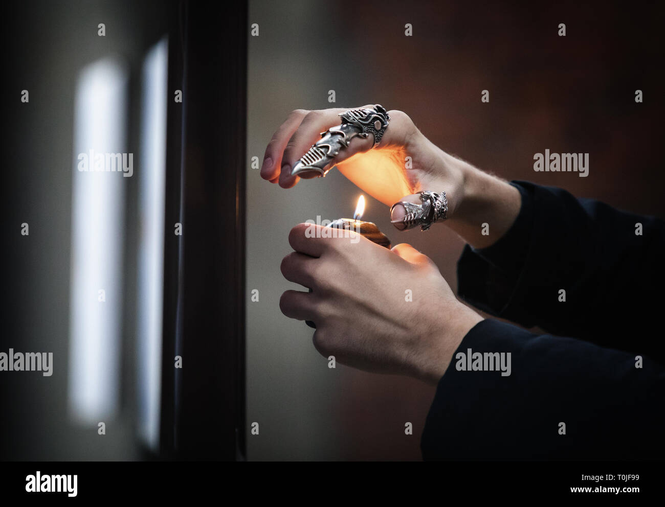 Hands of a psychic with a candle in the process of ritual, the occult ...