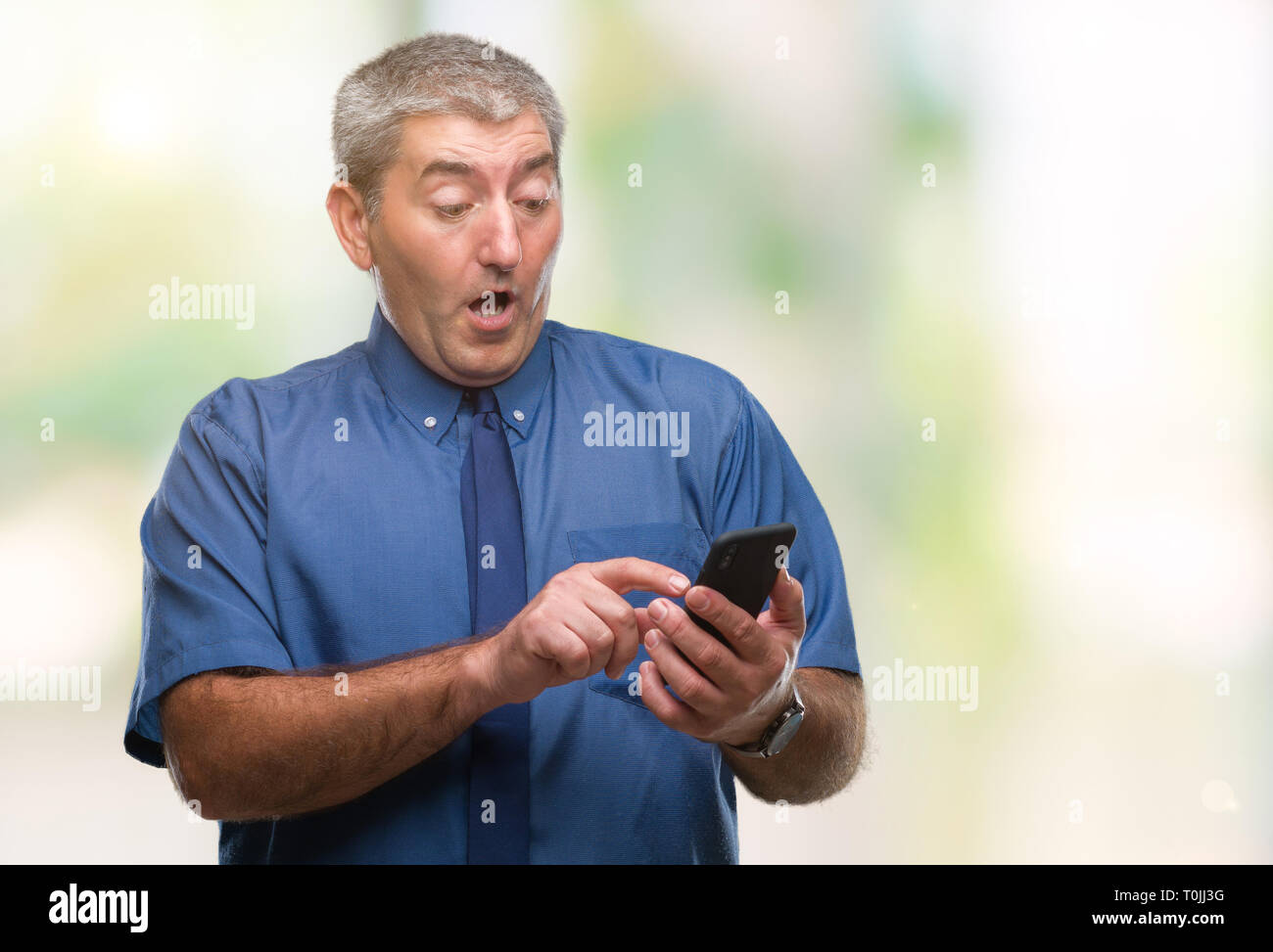 Handsome senior man texting sending message using smartphone over ...