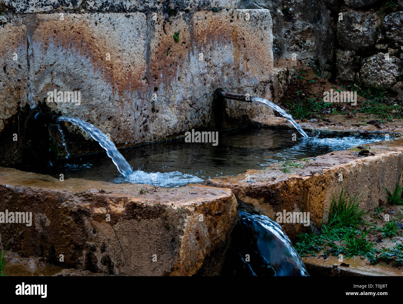 Natural trough with three water outlets Stock Photo - Alamy
