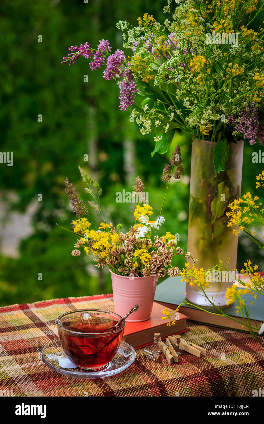 Summer tea with a book on the terrace. Summer tea with a bouquet of ...