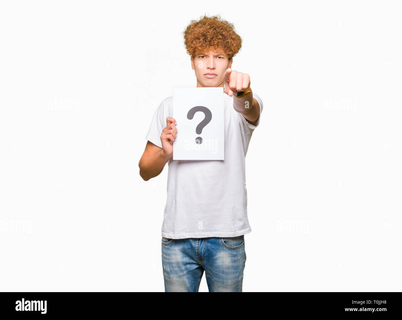 Young handsome man holding paper with question mark pointing with ...