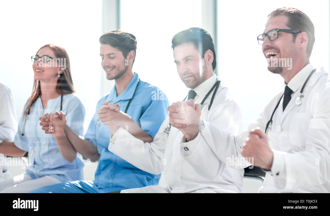 doctors sit in a row and hold hands of each other Stock Photo - Alamy