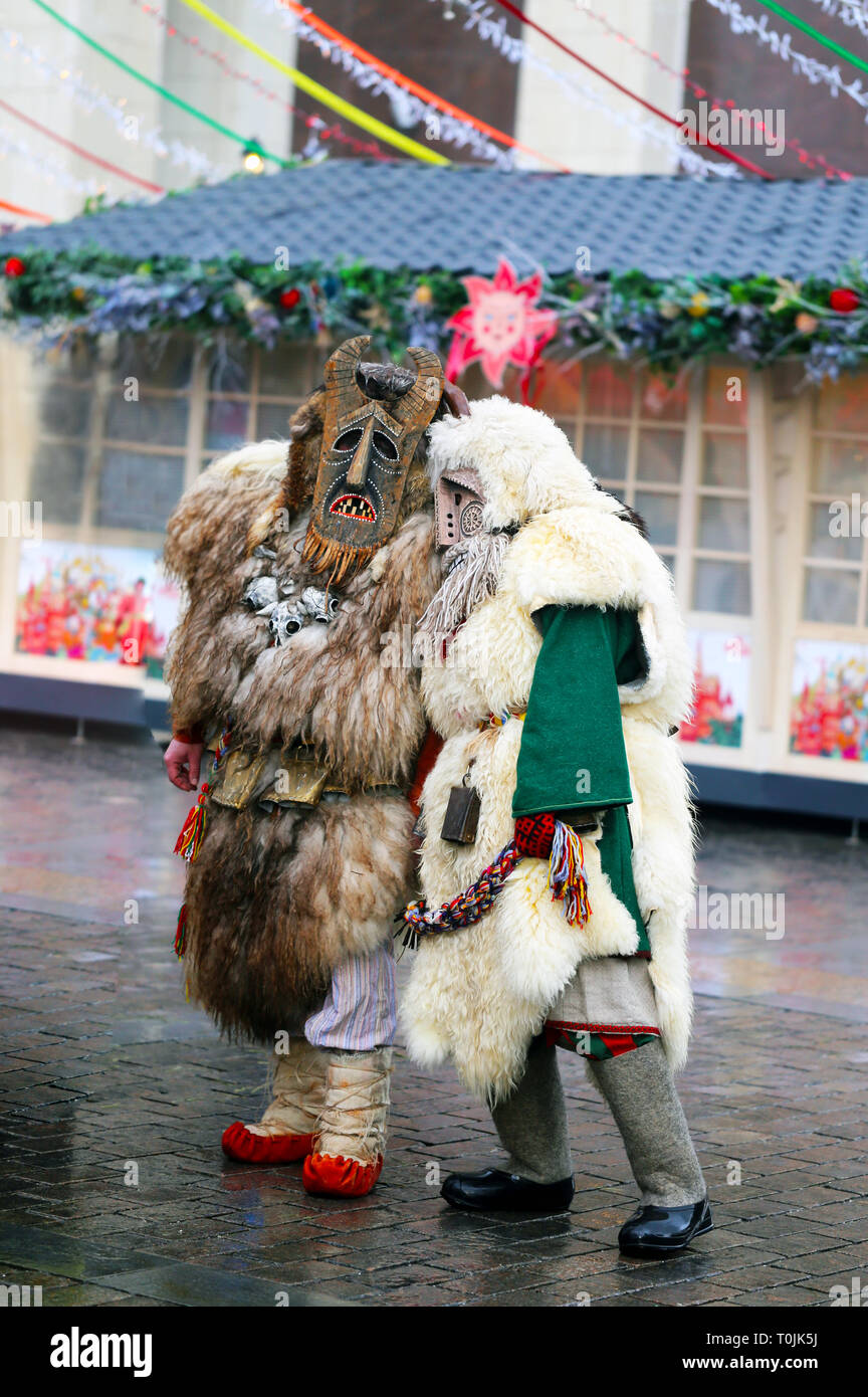 People in national Russian folk costumes in masks of ancient idols ...