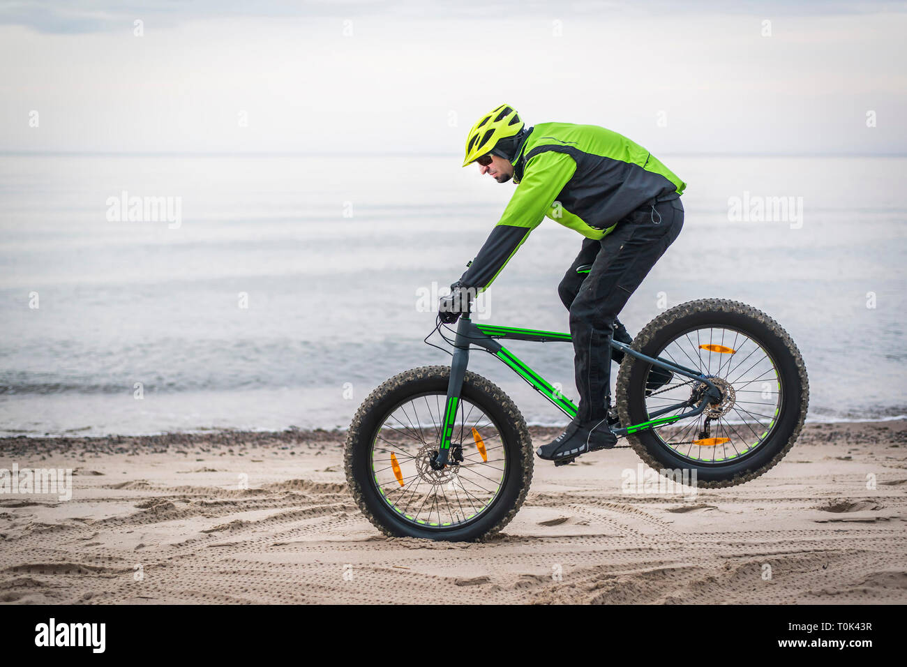 Young man on fat bike riding on the beach in february - Poland Stock ...