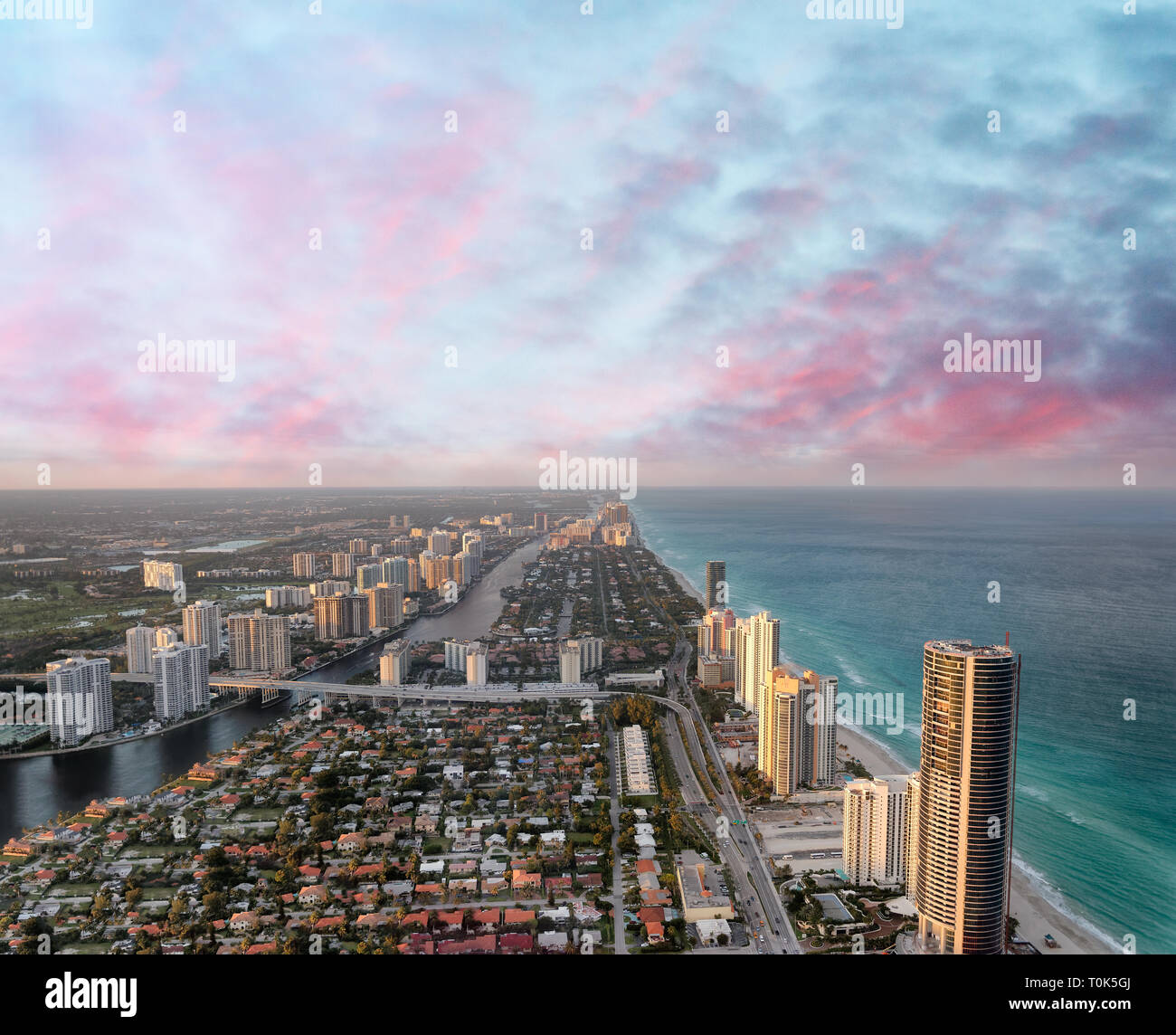 Aerial view of Miami Beach at sunset from helicopter. City skyline and ...