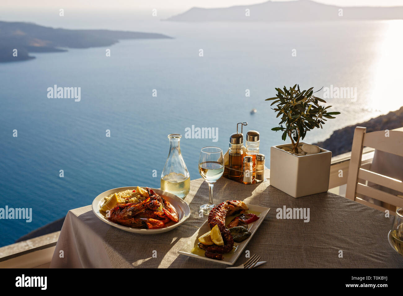Romantic dinner for two at sunset.Greece, Santorini, restaurant on the ...
