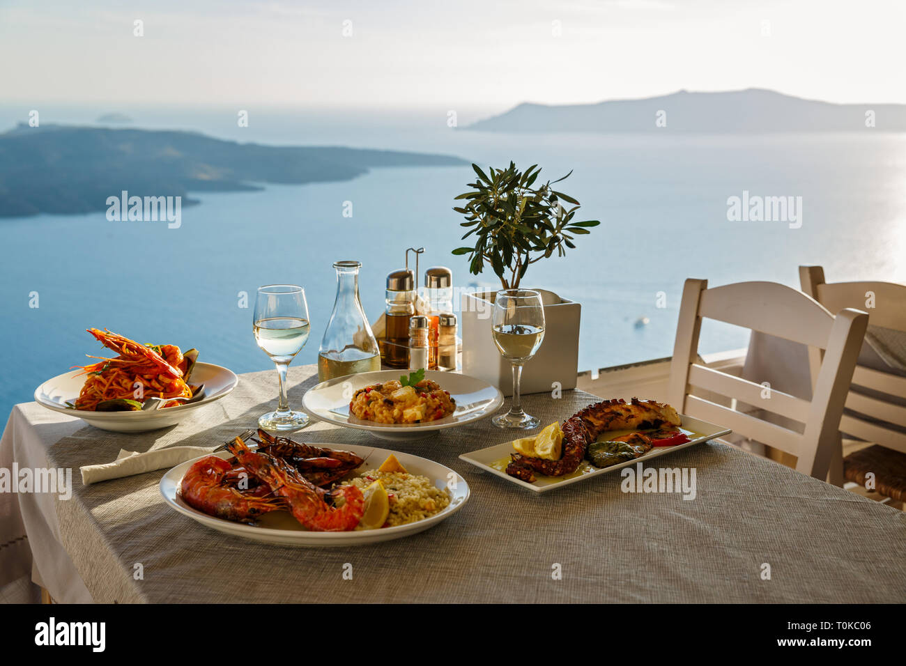 Romantic dinner for two at sunset.Greece, Santorini, restaurant on the ...