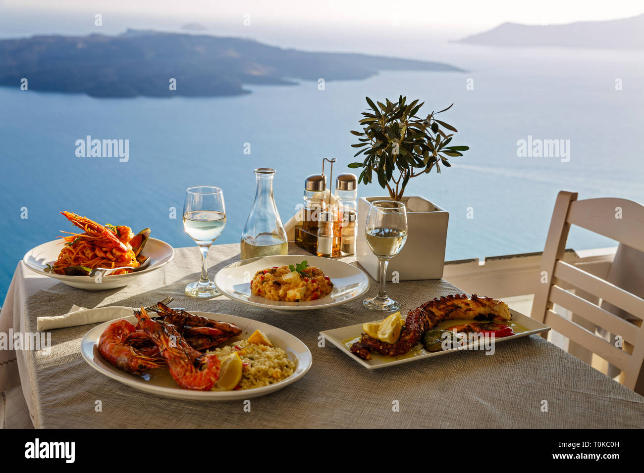 Romantic dinner for two at sunset.Greece, Santorini, restaurant on the ...