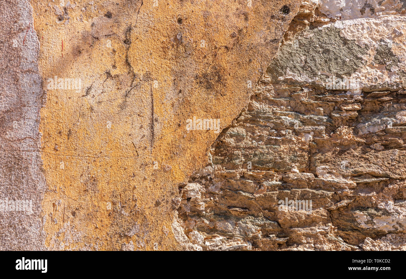Old, distressed stone wall, building facade. Painted orange color ...