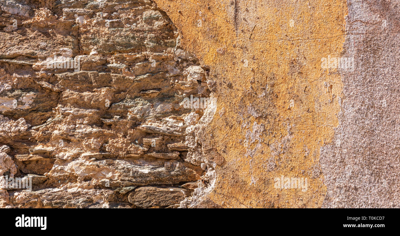 Old, distressed stone wall, building facade. Painted orange color ...