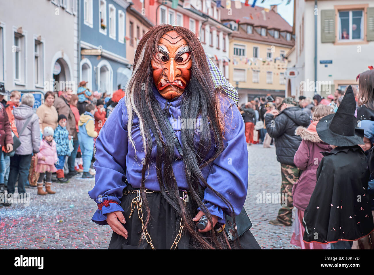 Witch in violet robe and with chain around the waist. Street Carnival ...