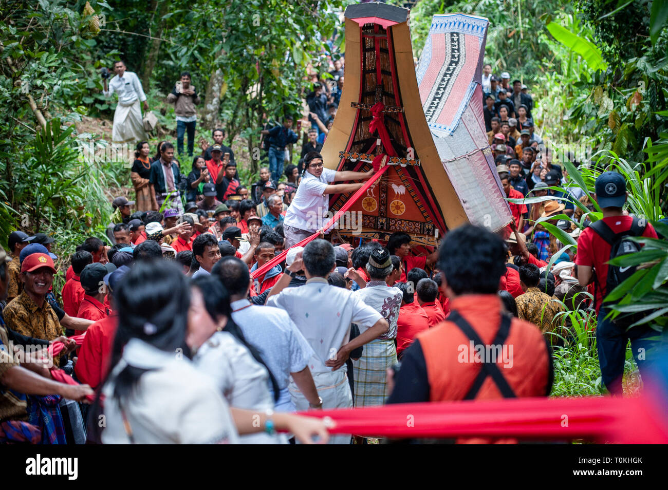 Residents are seen pulling red cloth and their relatives' coffins ...