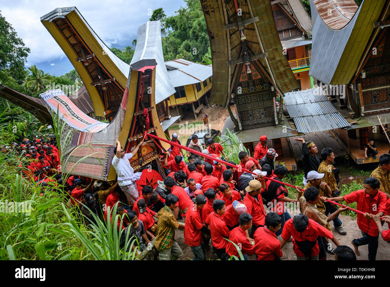Residents are seen pulling red cloth and their relatives' coffins ...