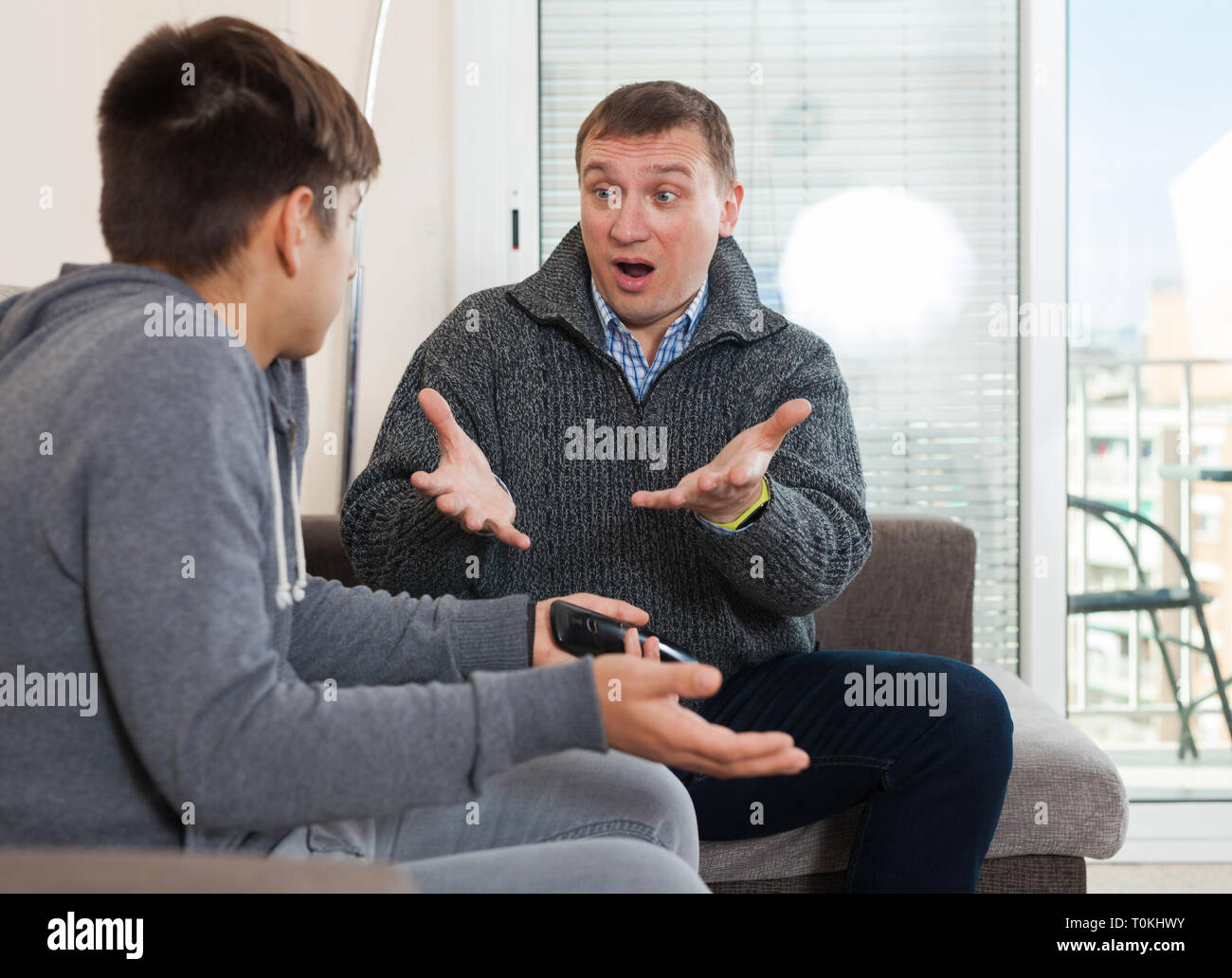 Dissatisfied father scolds young son Stock Photo - Alamy