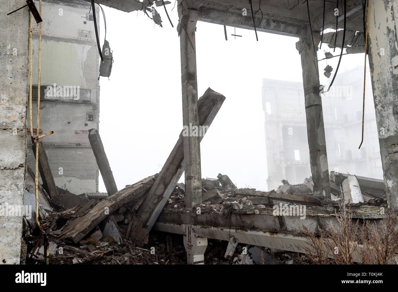 The remains of a large building destroyed in a foggy haze. Concrete ...