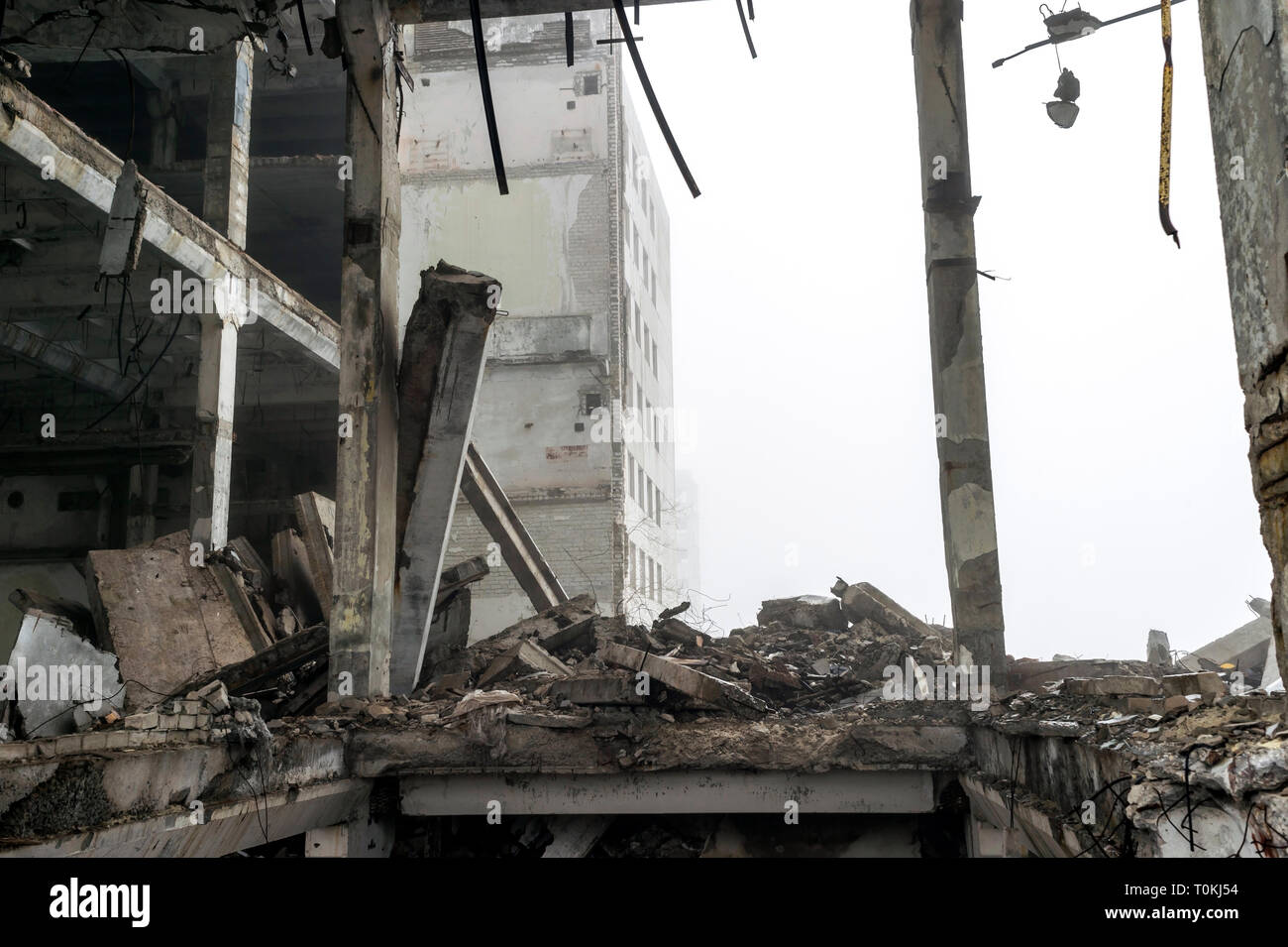 The remains of a large building destroyed in a foggy haze. Concrete ...