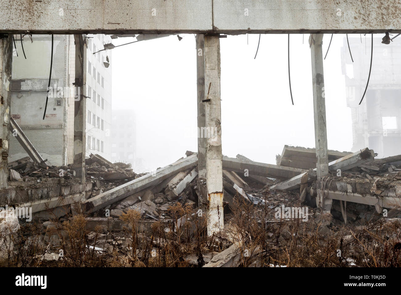 The remains of a large building destroyed in a foggy haze. Concrete ...