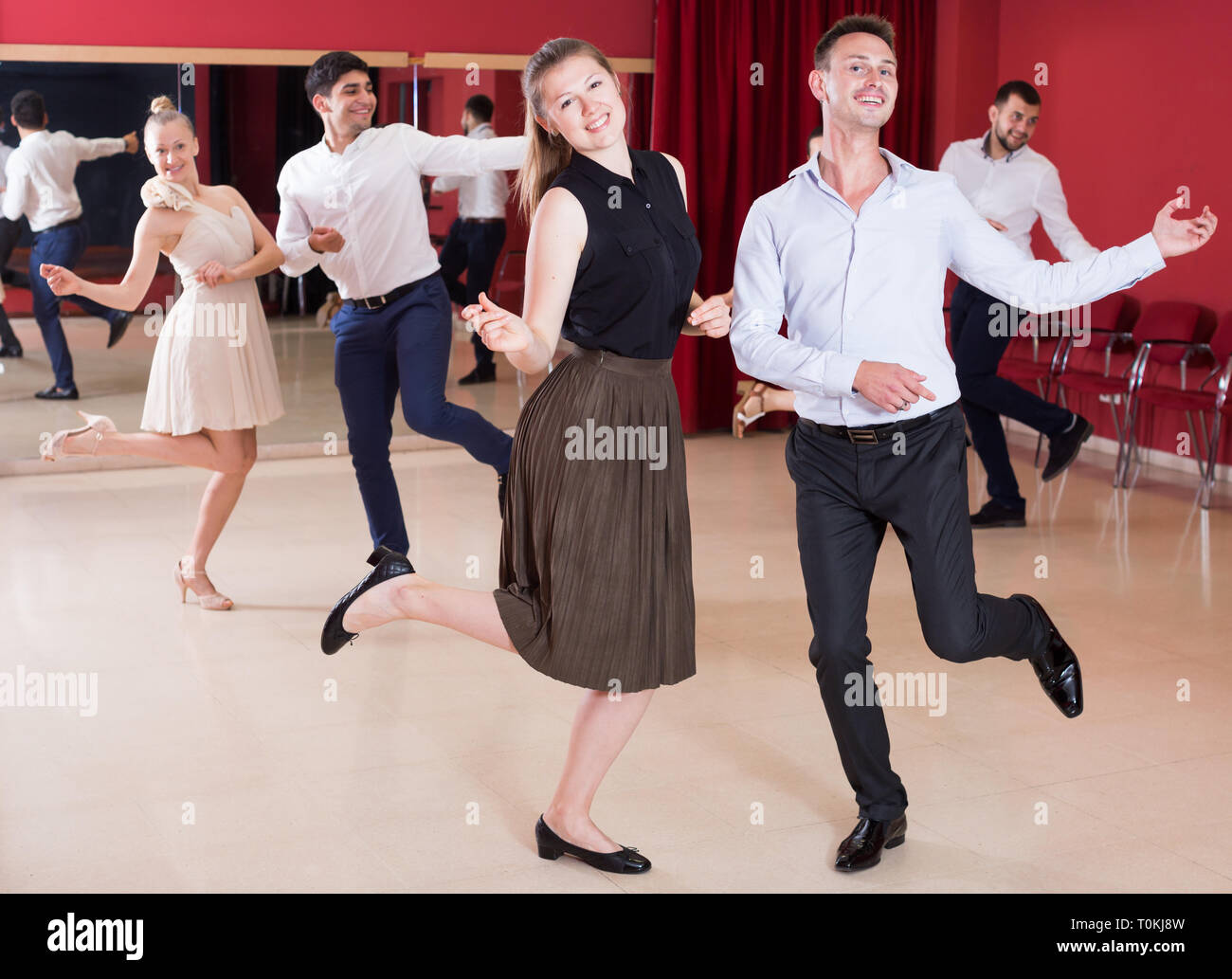 Adult dancing couples enjoying active dance in modern studio Stock ...
