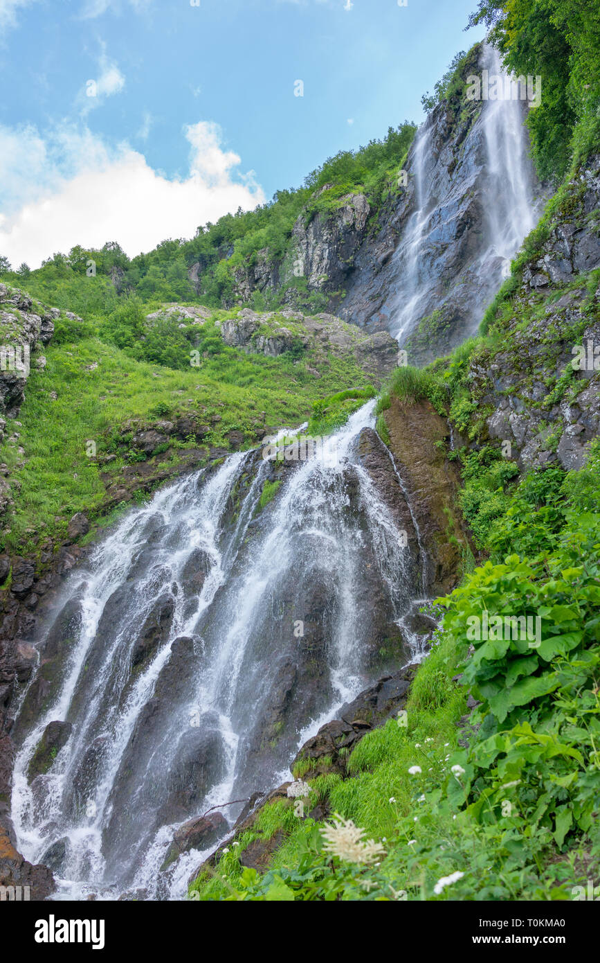 High powerful waterfall falls from the green mountain Stock Photo - Alamy