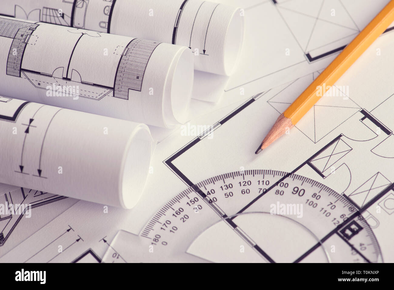 Toned and selective focus image.Several rolls of blueprints on an open ...