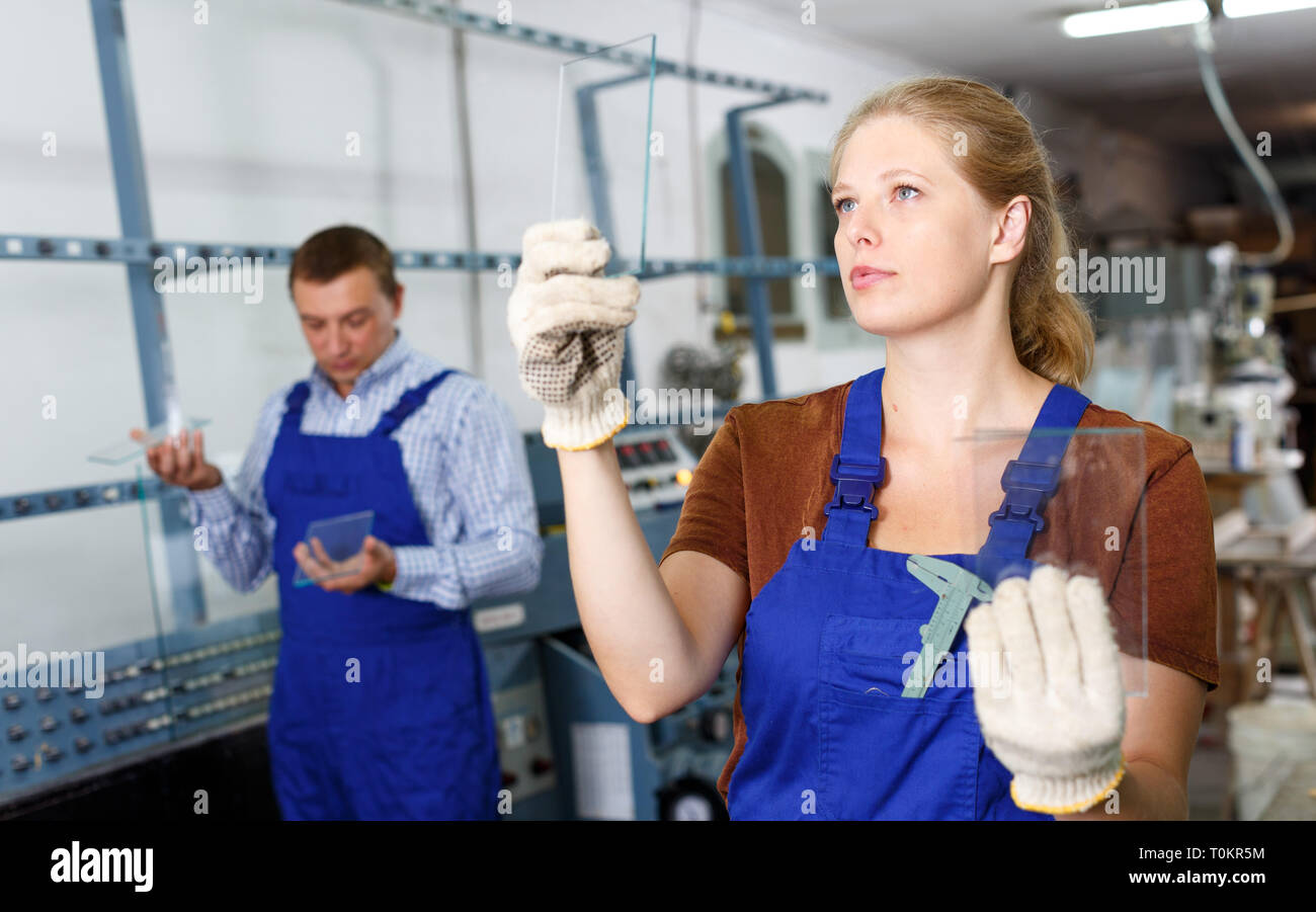 Portrait of qualified female glazier during daily work in glass factory ...