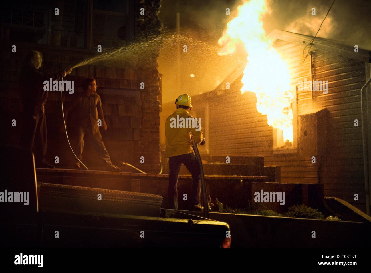 Two individuals extinguishing a house on fire Stock Photo - Alamy