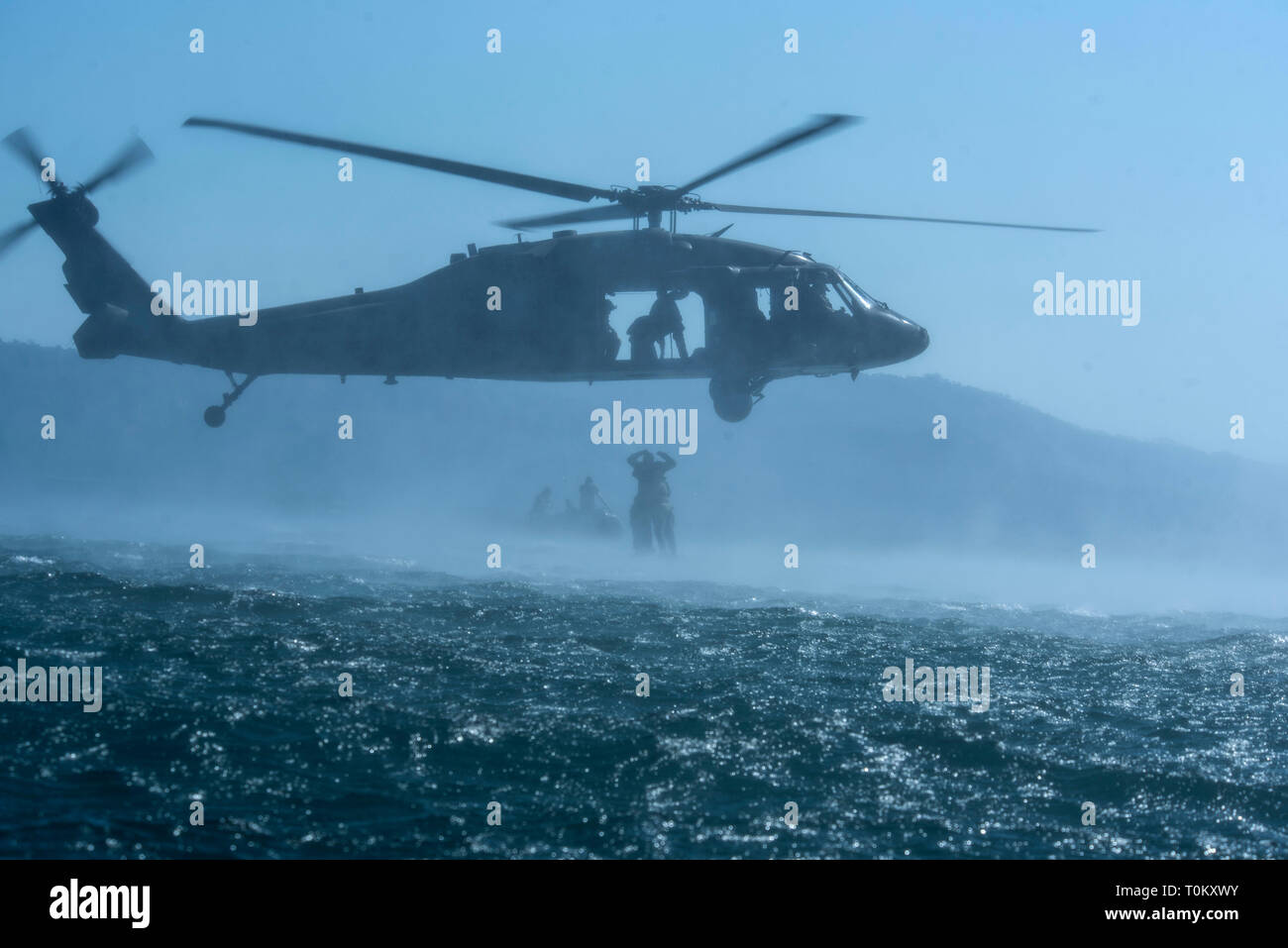 Service members practice helocasting by jumping into a lake from a UH ...